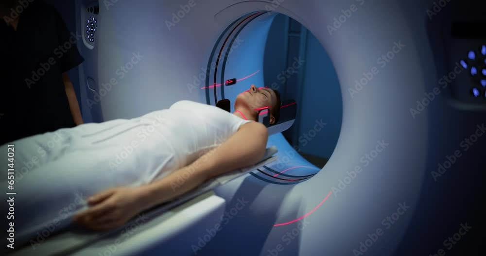 Zoom out Portrait of a Female Patient Lying on a CT or MRI Scan, Bed is Moving Inside the ...