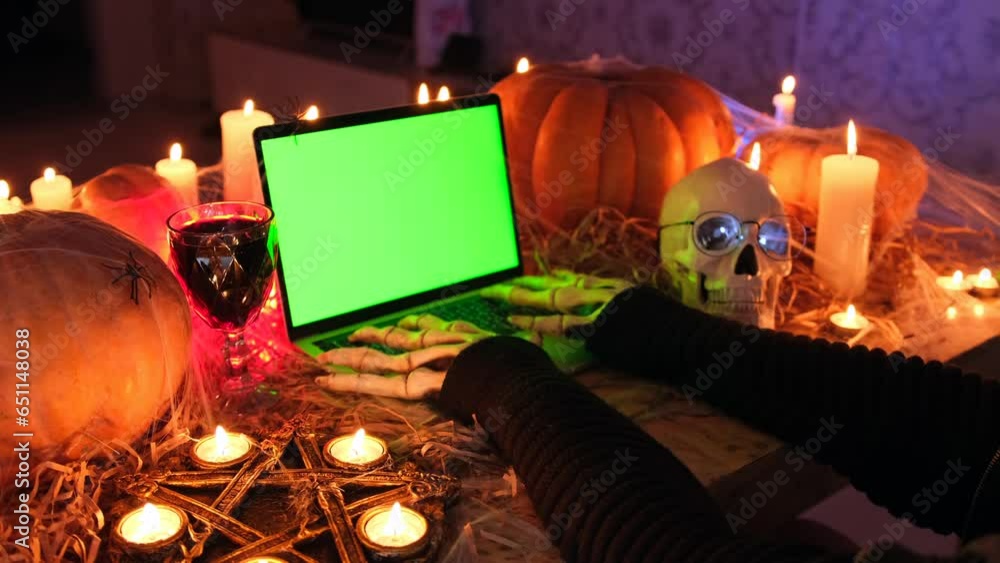 Skeletal hands dramatically types on laptop keyboard with green screen ...