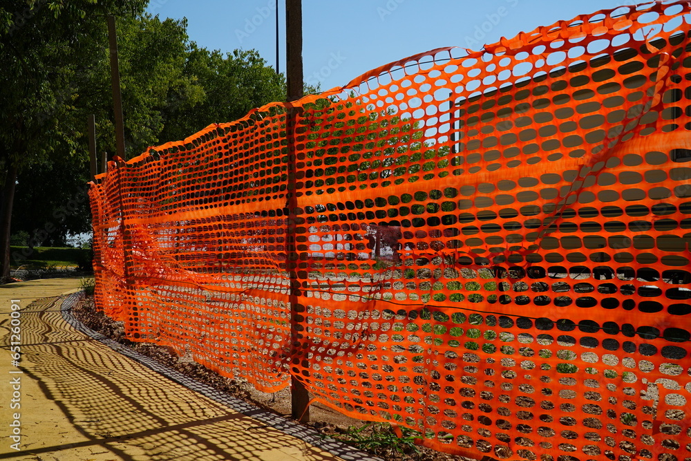 Orange plastic fence structure on the construction site, lattice fence ...