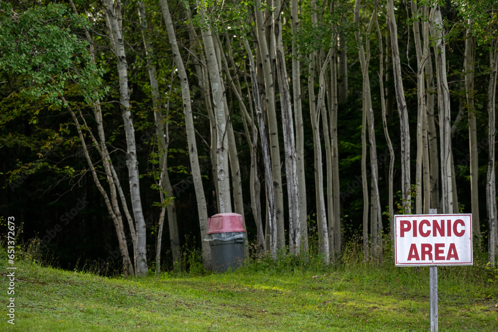 A small sign with a picnic area in red letters on a white board and ...