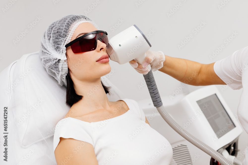 Laser hair removal face of a beautiful woman in a beauty salon. Laser ...