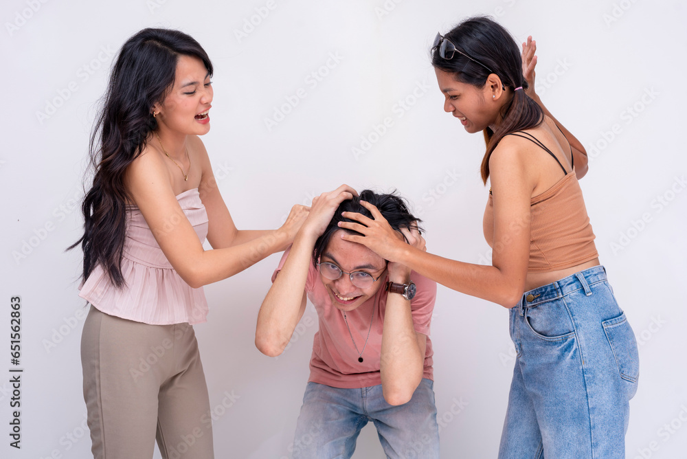 A young asian man getting ganged up on by two furious women insulted by ...
