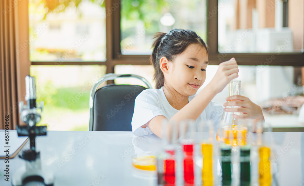 little scientist looking through a microscope and test tubes filled ...