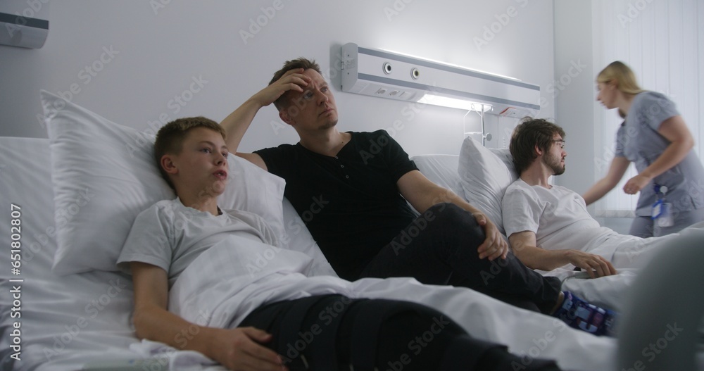 Father, kid and neighbour patient rest in hospital room and emotionally ...