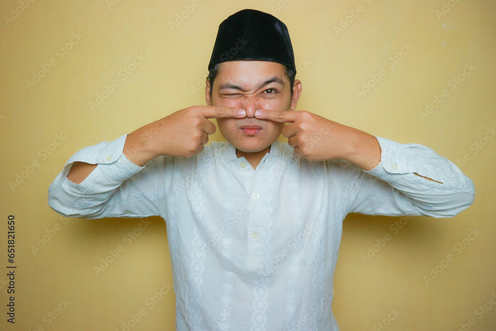 an Indonesian Muslim man of Asian descent wearing Muslim clothes and a ...