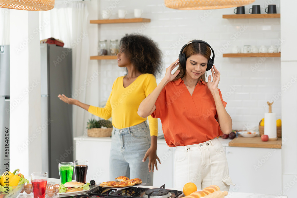 LGBT couple and kitchen with a two young woman dancing in a kitchen ...