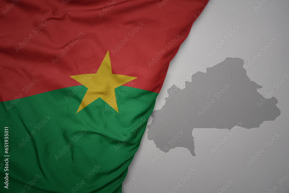 big waving national colorful flag and map of burkina faso on the gray ...