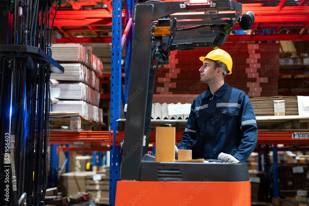 Male warehouse worker using forklift electric or electric pallet ...