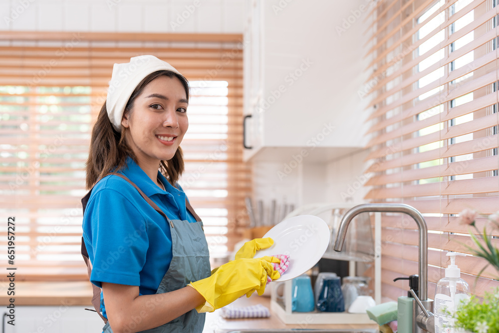 Beautiful Asian woman wearing blue shirt with yellow rubber gloves ...