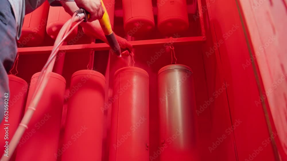 Worker operating using special gun for powder painting. Industrial ...