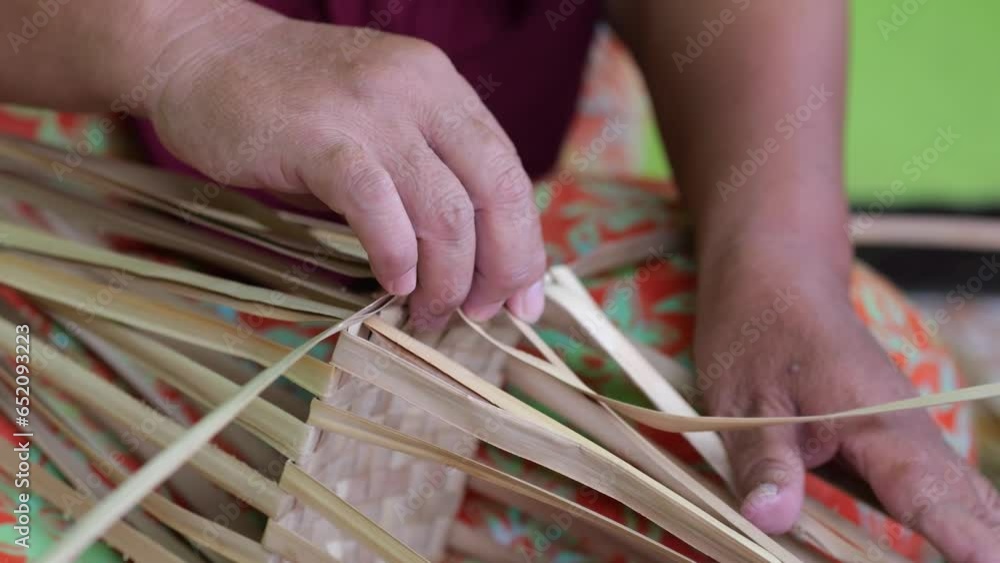 An Indonesian woman´s hand weaving an ancestral basket case from ...