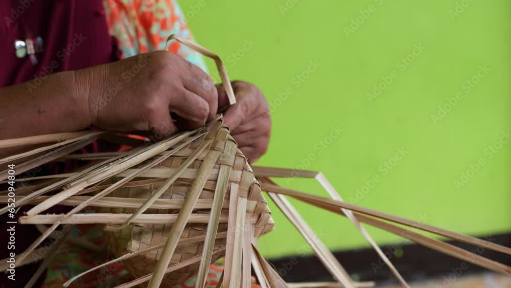 An Indonesian woman´s hand weaving an ancestral basket case from ...