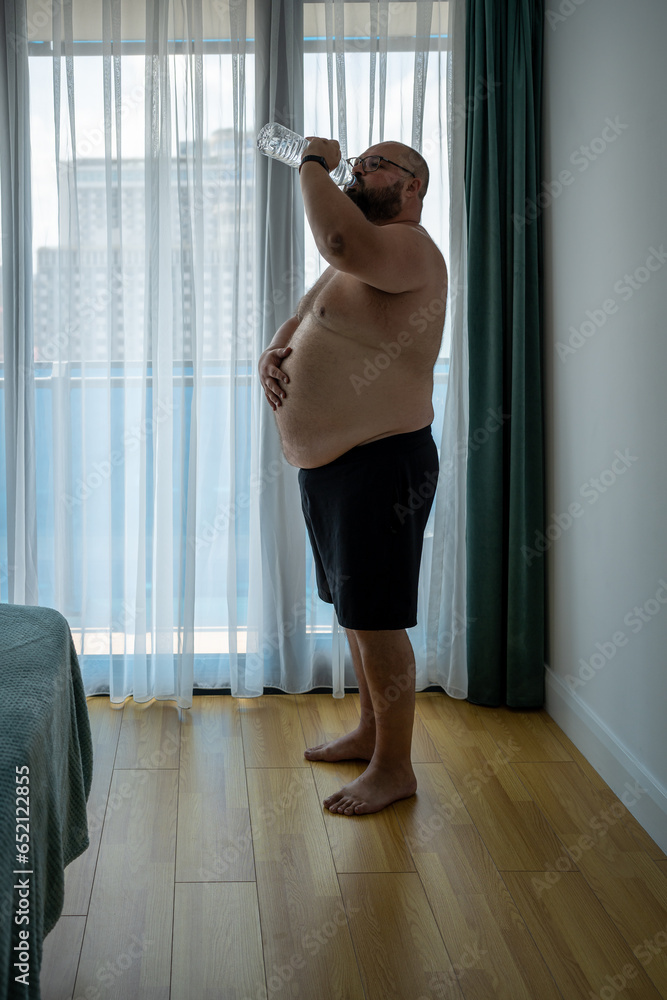 Fat man suffers dying from heat. Young naked overweight obese guy in ...