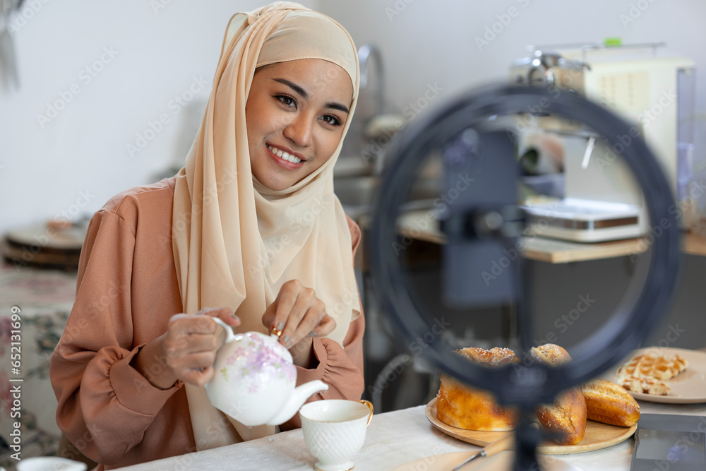 Young Muslim woman in hijab showing off a menu of desserts, bread ...