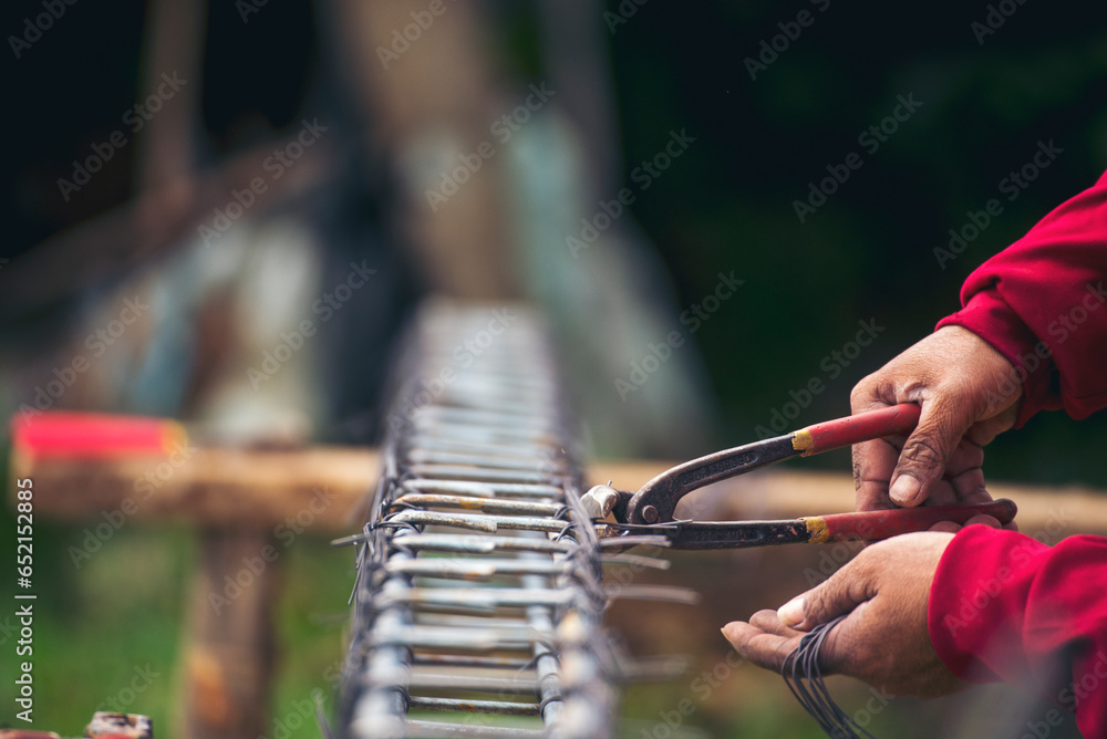 Men hands using pincer pliers iron wire reinforcement of concrete work ...