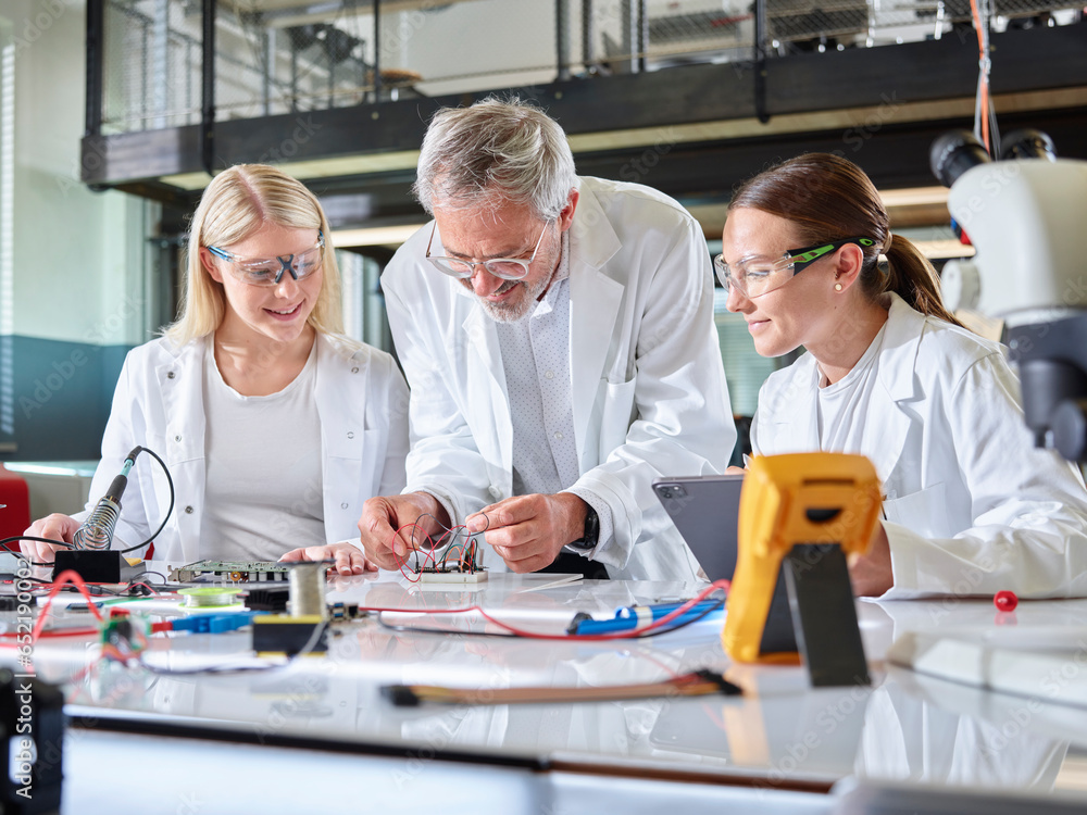 Professor teaching trainees with circuit board in laboratory Stock ...