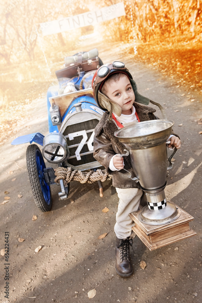 Little boy in the image of a racer finished on an old race car in an ...
