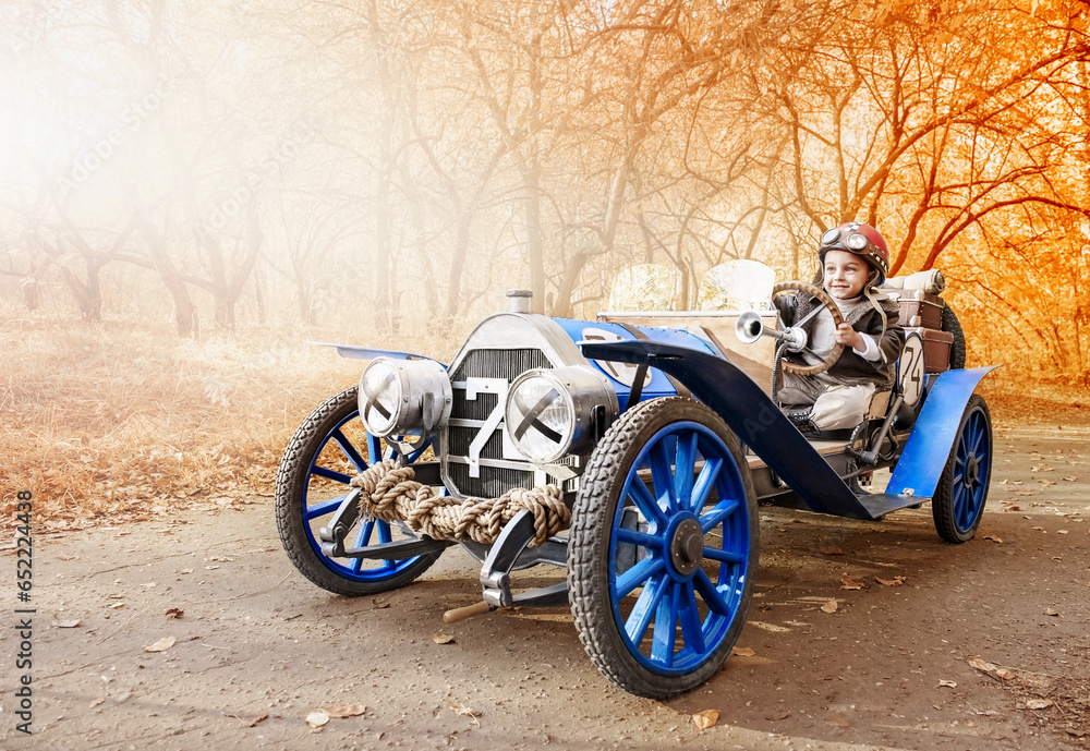 Little boy in the image of a racer finished on an old race car in an ...
