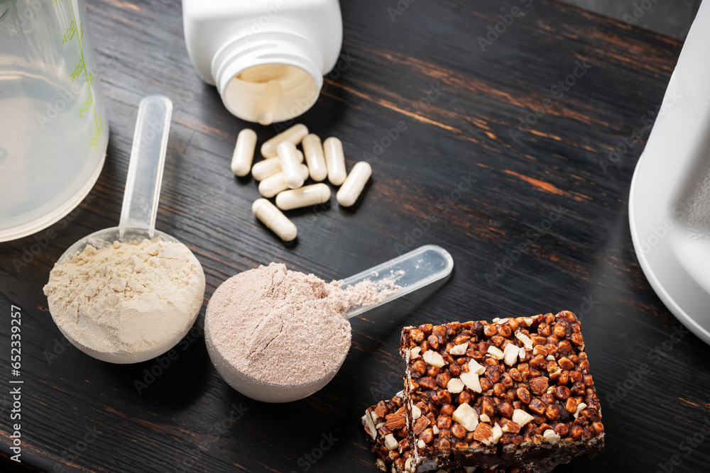 Two scoops of whey or soy protein powder, white capsules of amino acids ...