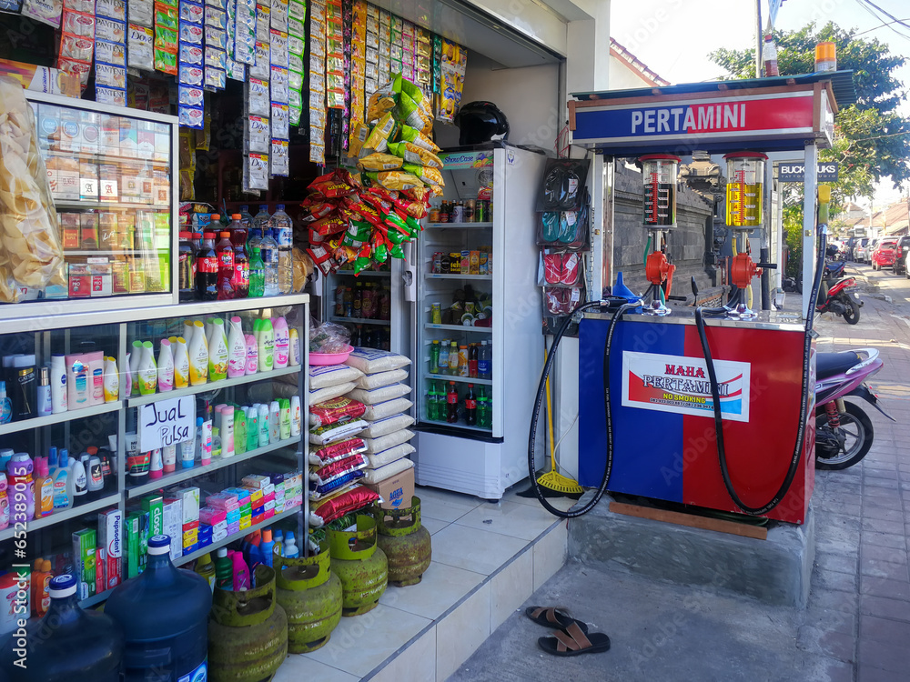 A red and blue gas pump in front of a grocery store in Bali, Indonesia ...