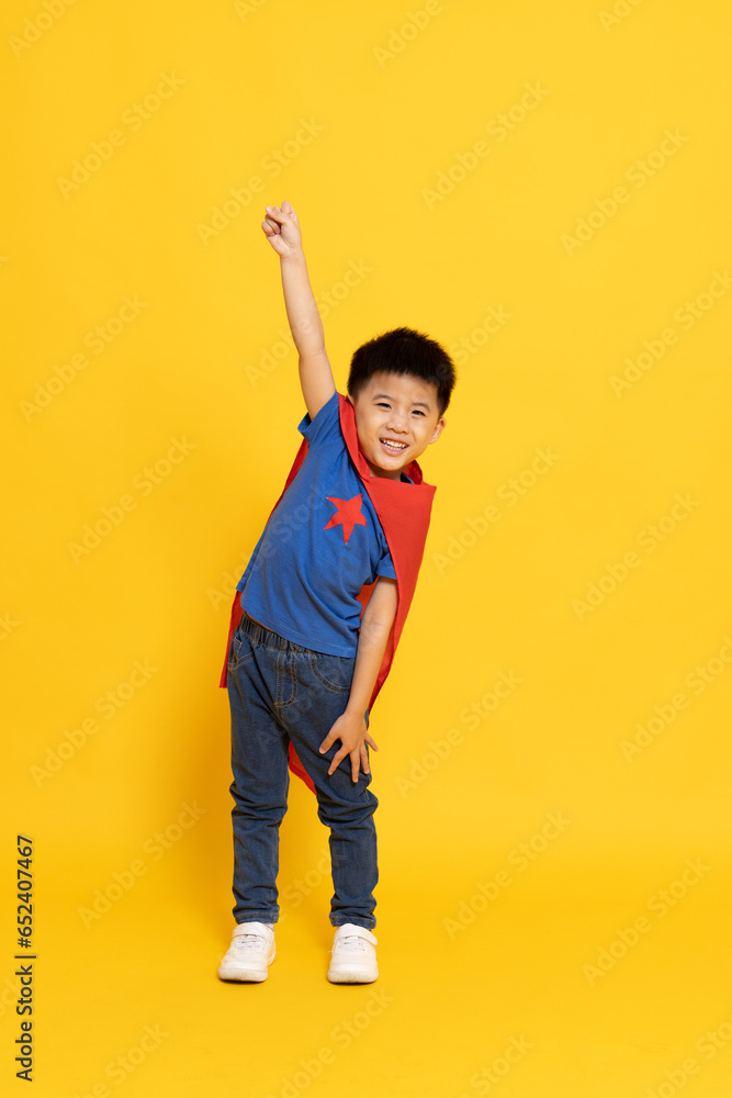 Superhero Asian boy smiling with red cape and raise arms isolated ...