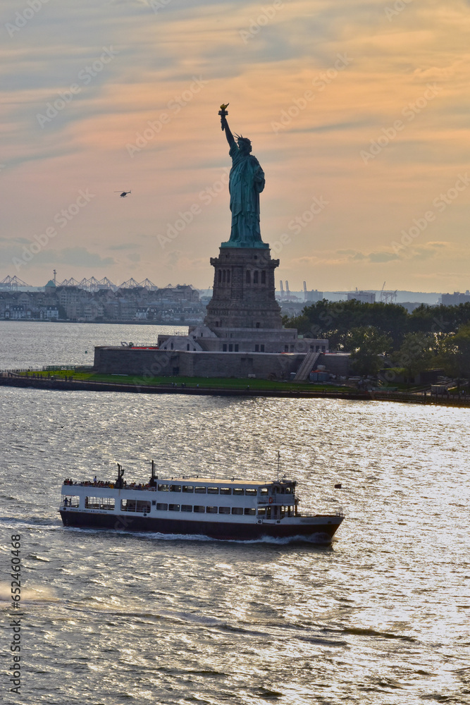 A sightseeing boat passes by the Statue of Liberty on the Hudson River ...