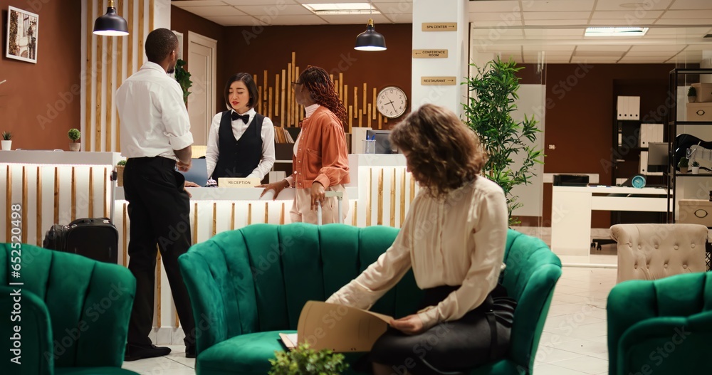 Busy hotel manager receiving cup of coffee from employee while checking ...