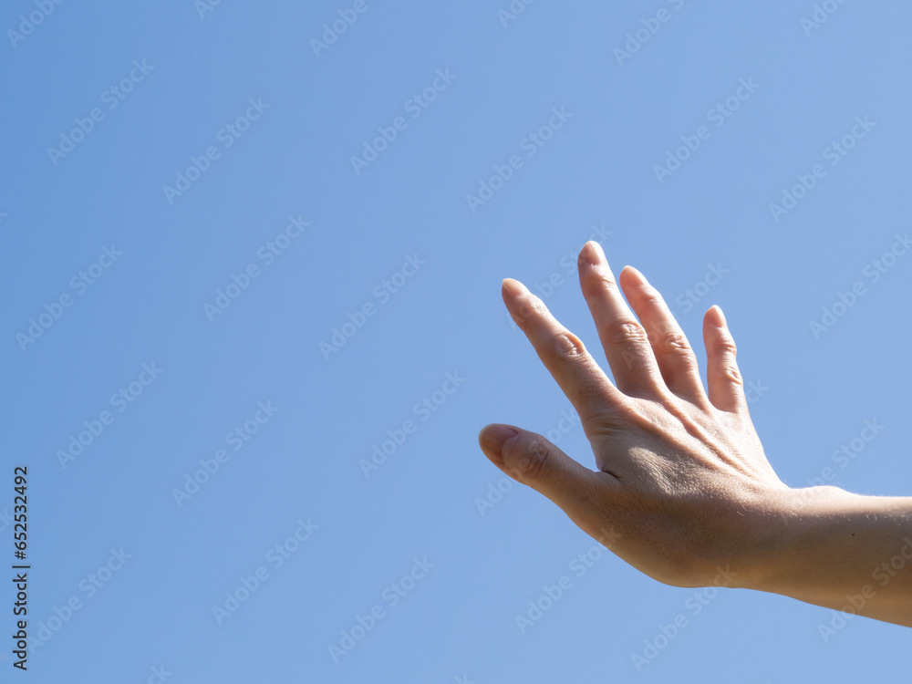快晴の青空に向かって伸ばした女性の手。 Stock Photo | Adobe Stock