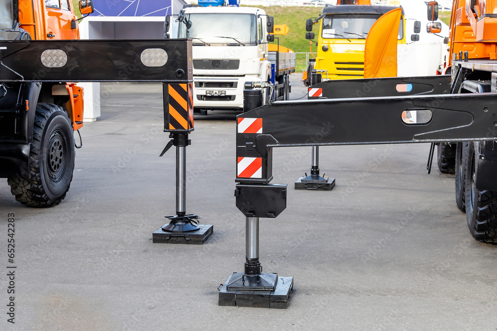 Outriggers of new wheeled cranes on wooden pads. Wheel cranes in a ...