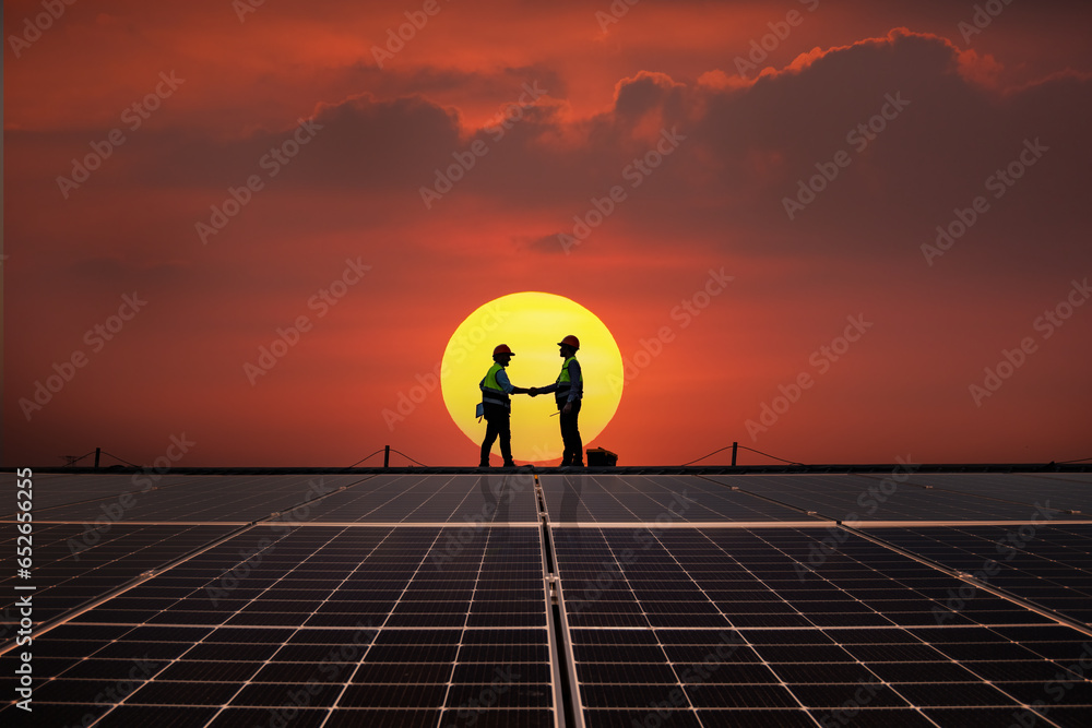 Silhouette engineer working on solar cell plant with windmill field ...
