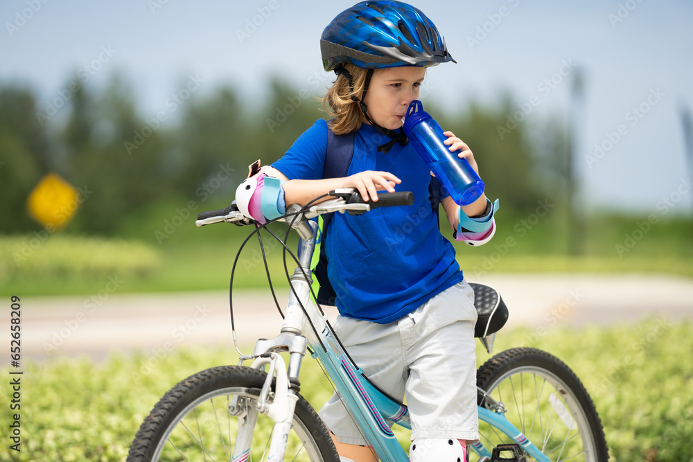 Child on bicycle. Boy in a helmet riding bike. Little cute caucasian boy in safety helmet riding ...