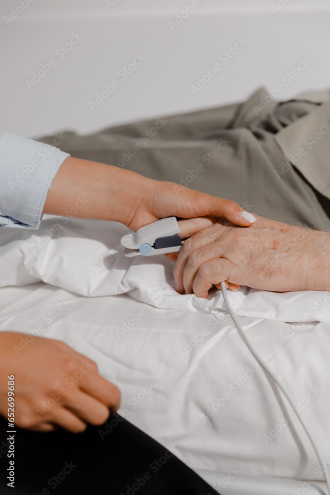 In the hospital room old man patient before surgery wearing on finger ...