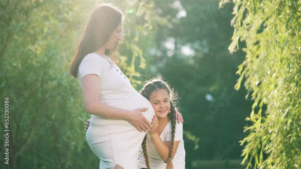 happy family. Daughter hugs belly of mother pregnant woman. Waiting for ...