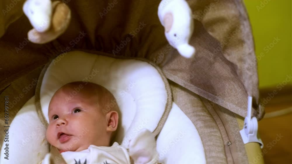 Newborn baby in electronic swing. A child on an electronic swing ...