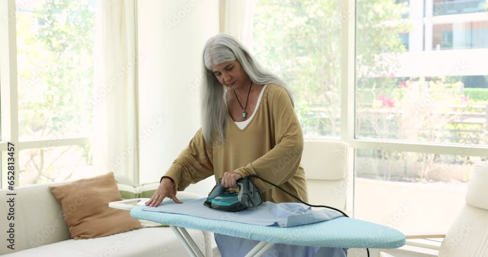 Attractive Serious Middle Aged Long Haired Woman Standing In Modern