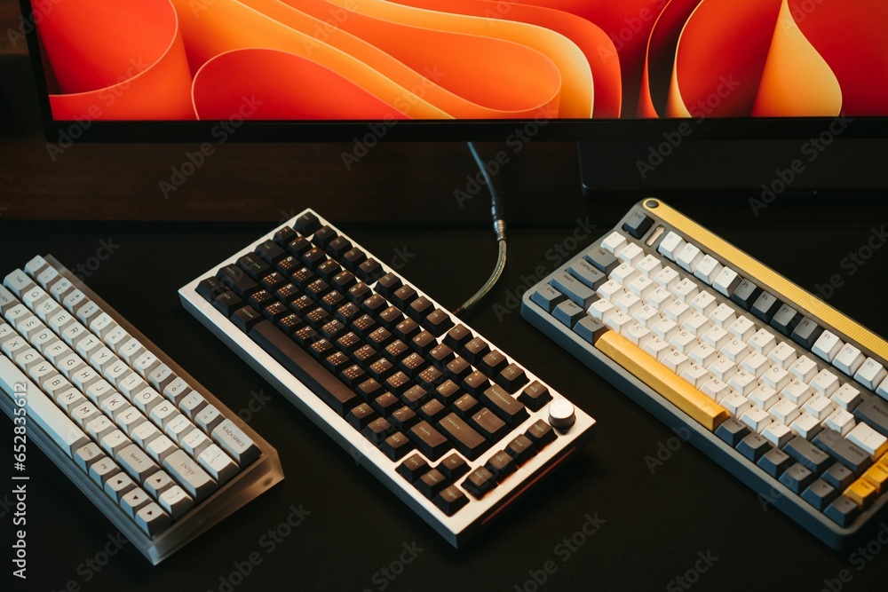Computer with three different mechanical keyboards lying on the desk ...