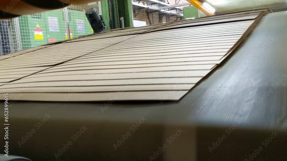 Production of corrugated cardboard. Corrugator machine cut the blanks ...