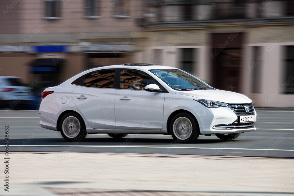 Changan Alsvin at the city road in motion. White car driving along the ...