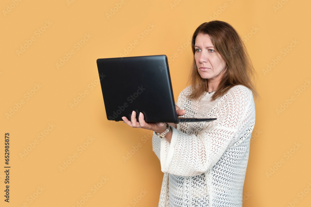 A woman with an alert sad face looks at the laptop screen, reads world ...