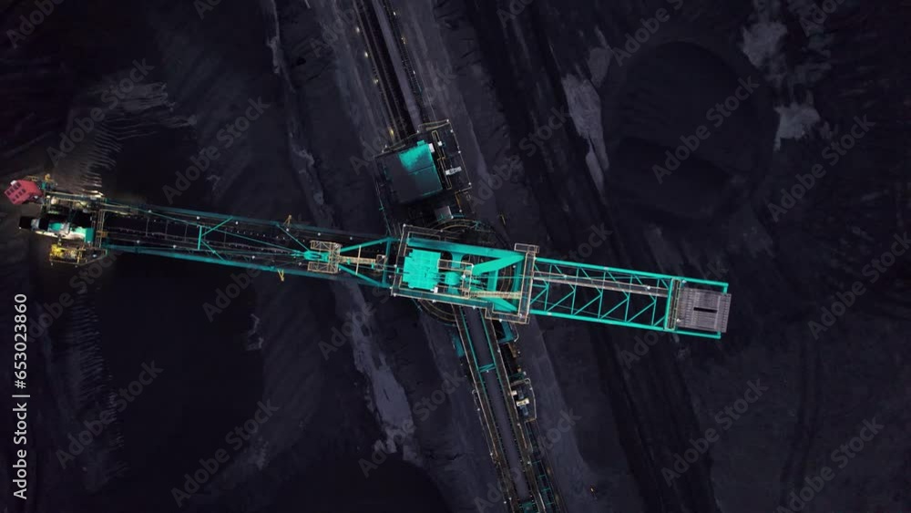 Rotary shovel at coal pile loading freight vessels at bulk shipping ...