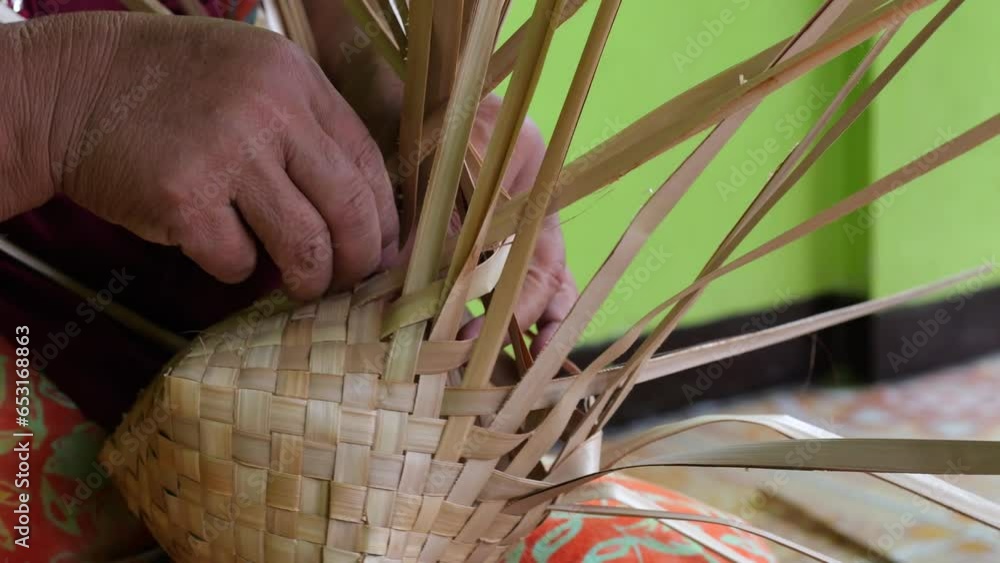 An Indonesian woman´s hand weaving an ancestral basket case from ...