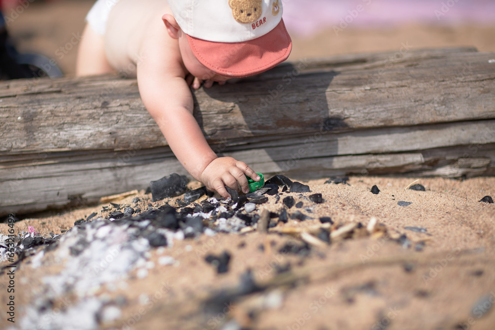 baby in the sand dirty face, bacteria in the mouth, danger of poisoning ...