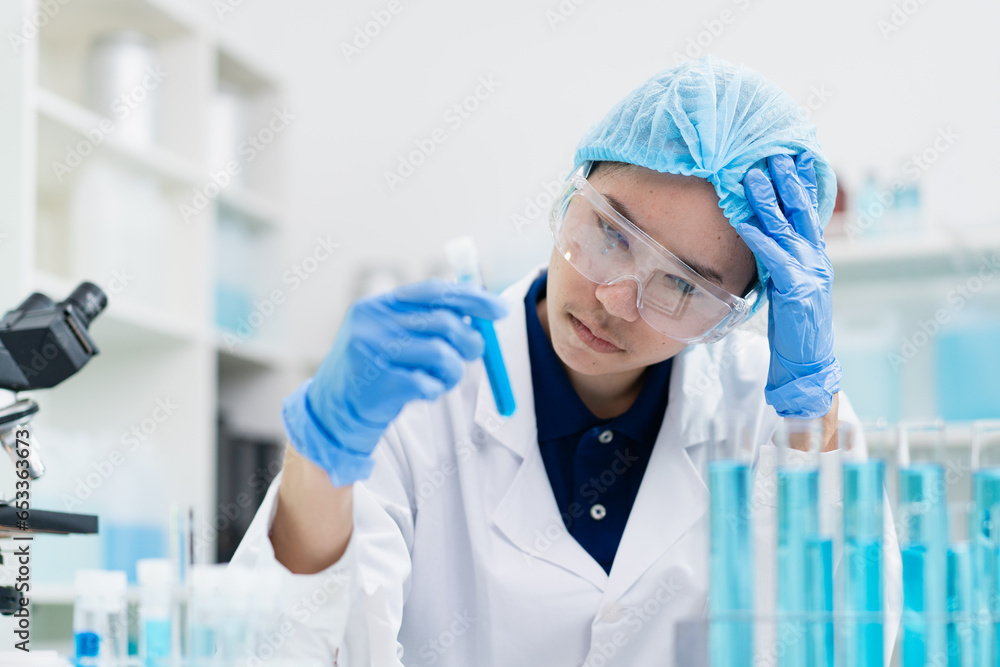 asian female scientist feeling stress and tired from working overtime ...