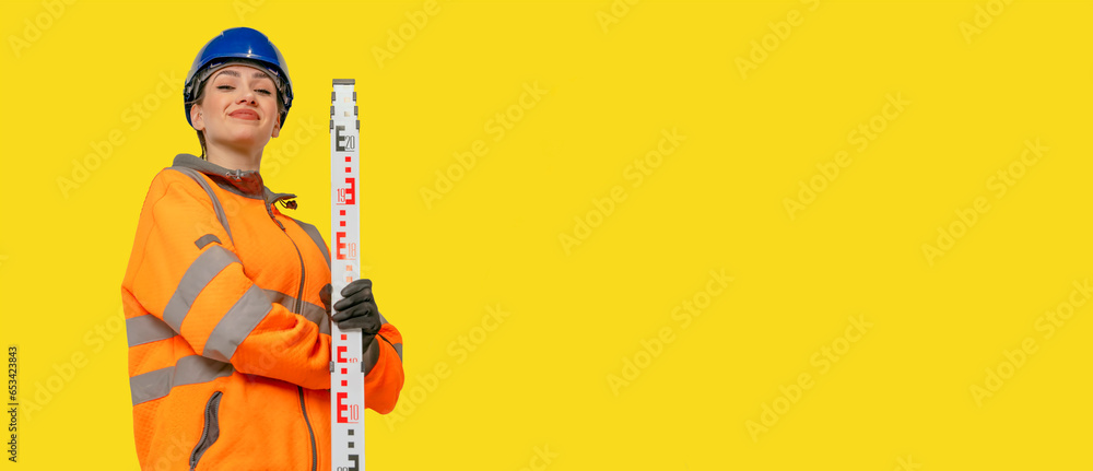 Woman in hard hat and protective clothes land surveyor working with ...