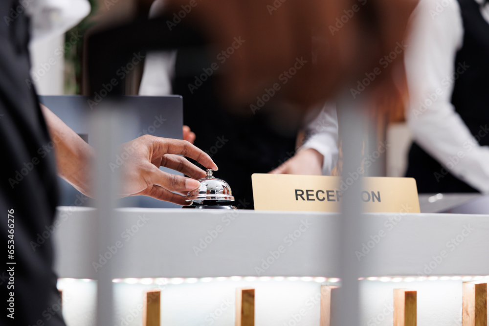 Person ringing service bell at counter, using bell to call out hotel ...