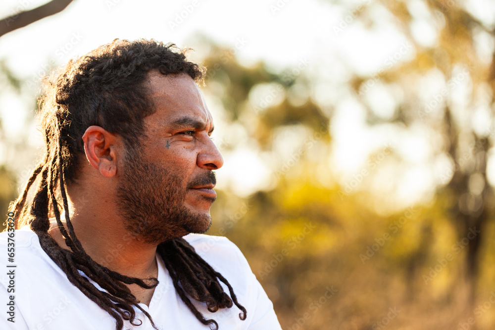 Side profile portrait of aboriginal man looking away with dreadlocks ...