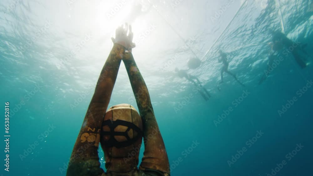 Female freediver ascends along the rope during freedive training ...