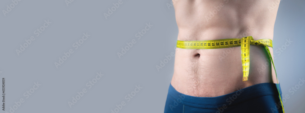 Male torso and measuring tape on a gray background. Unrecognizable ...