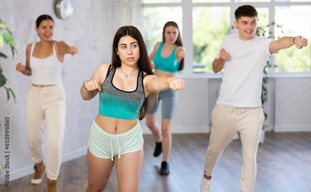 Female teenager performs movements during warm-up, limbering-up part of ...