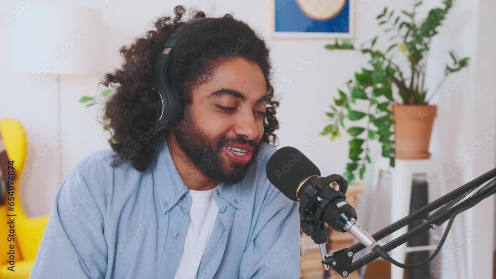 Young happy successful Arabian man reporter takes off headphones and ...